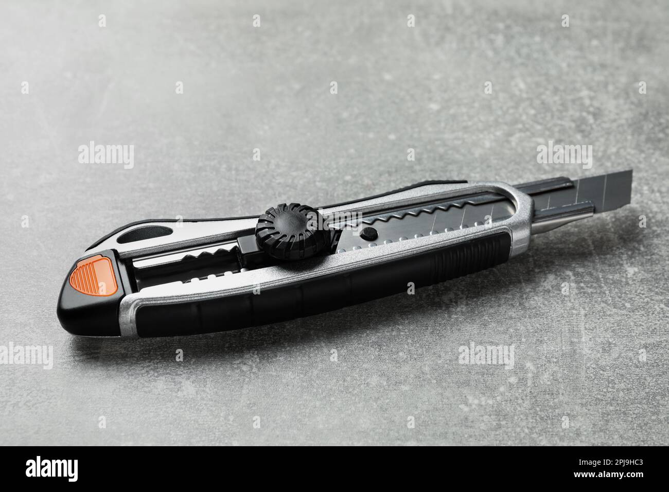 Utility knife on light grey table. Construction tool Stock Photo - Alamy