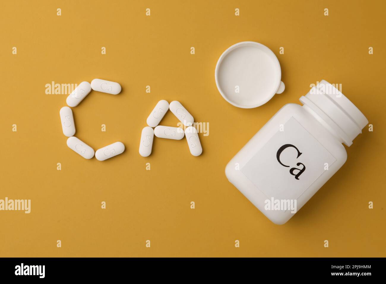 Calcium supplement pills and jar on yellow background, flat lay Stock ...