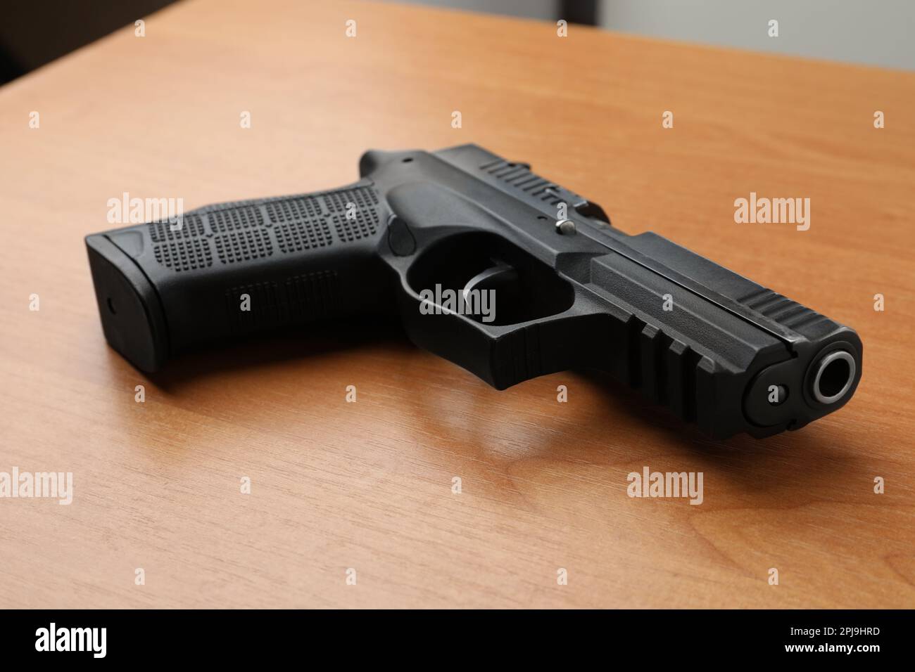 Semi-automatic pistol on wooden table. Standard handgun Stock Photo - Alamy