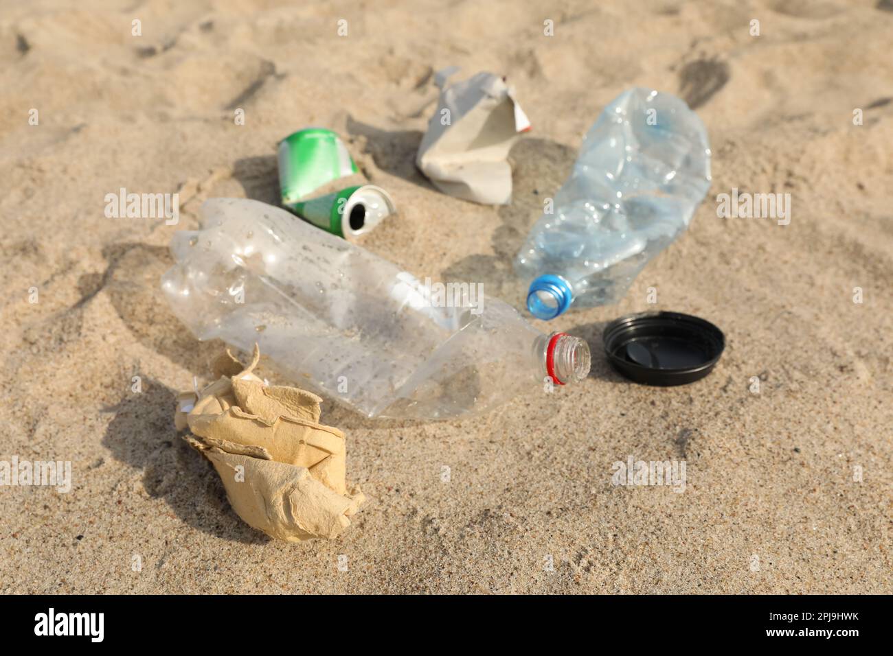 Garbage scattered on sand, closeup. Recycling problem Stock Photo - Alamy