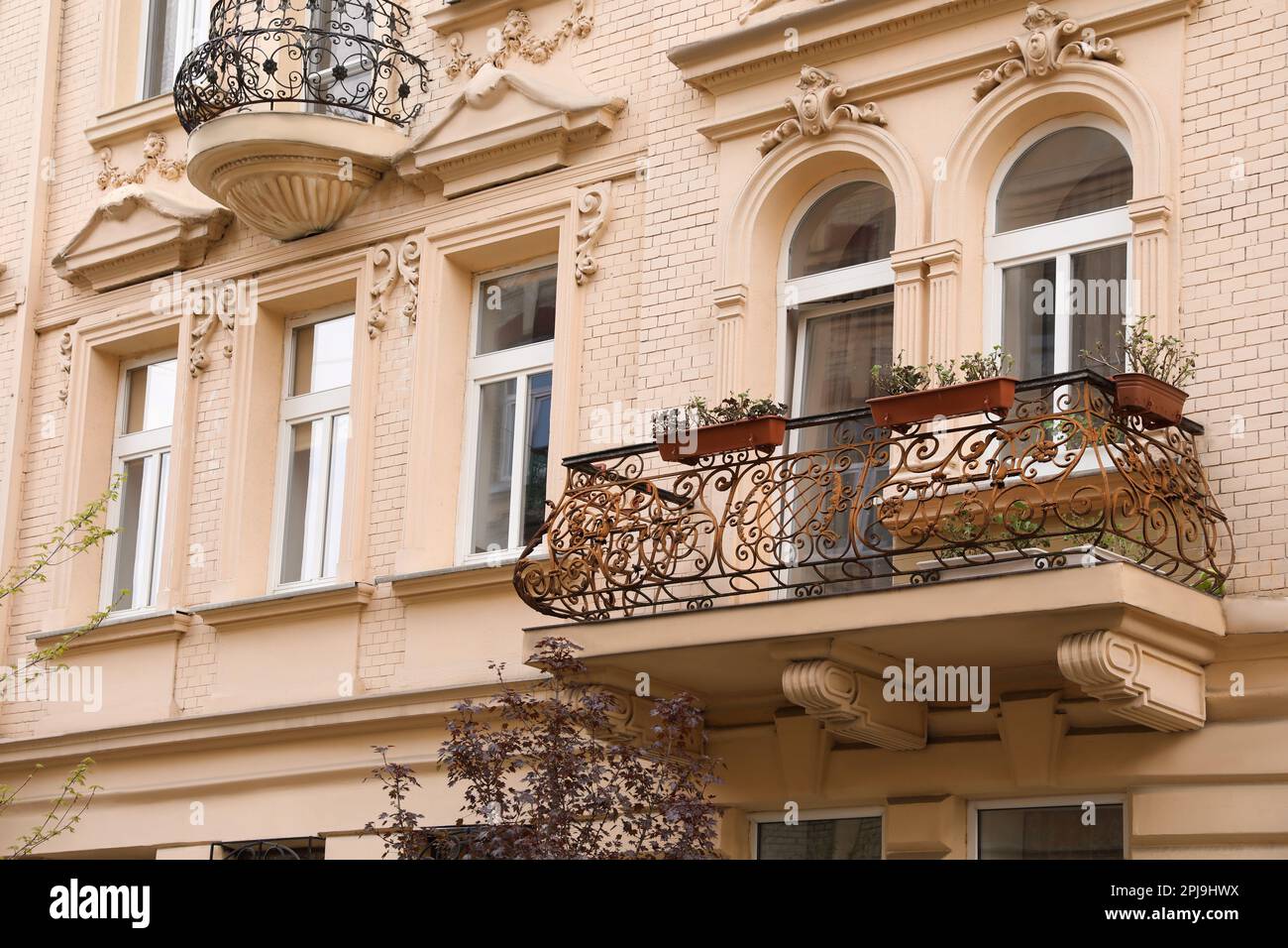 Exterior of beautiful beige building with balconies and stucco decor ...