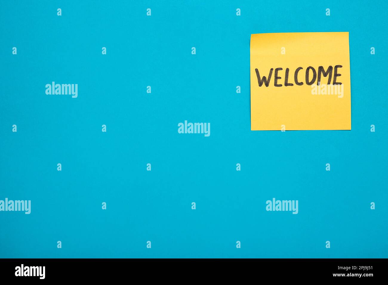 Paper note with word Welcome on turquoise background, top view. Space ...