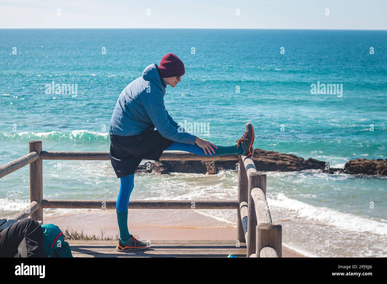 Hiker stretches his stiff and shortened muscles in between his hike ...