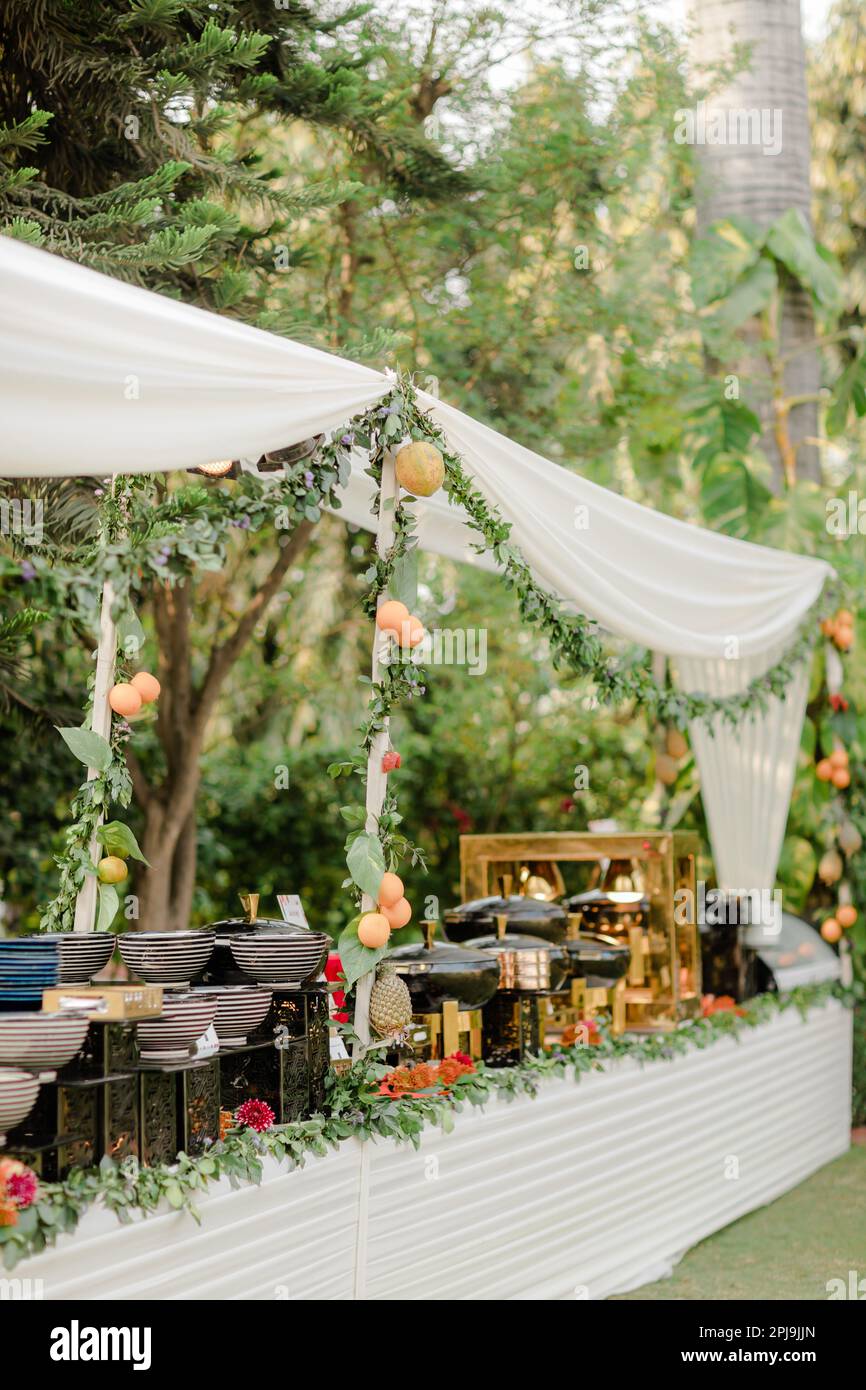 An outdoor buffet featuring a variety of vibrant colored dishes set up ...