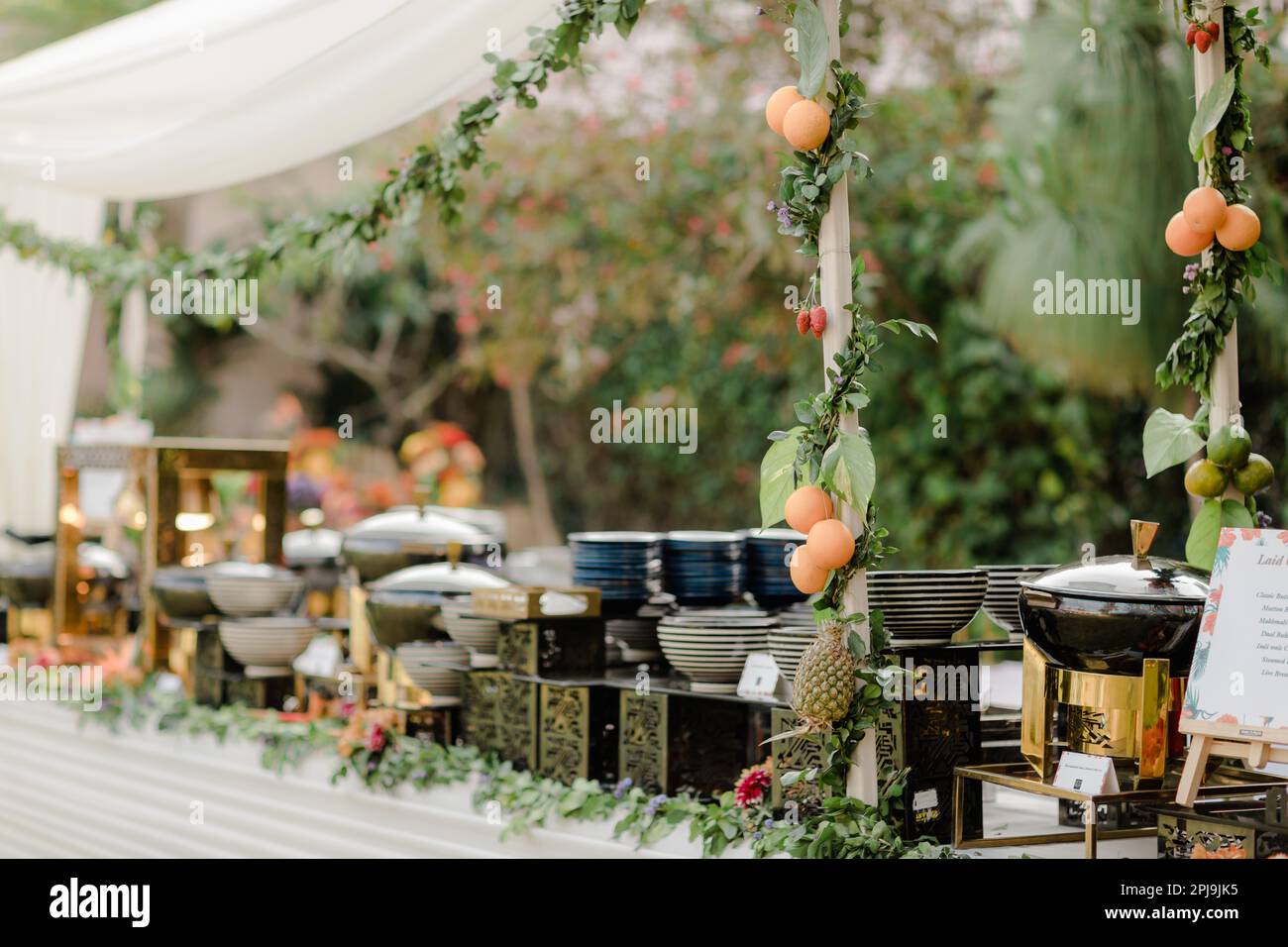 An outdoor buffet featuring a variety of vibrant colored dishes set up ...