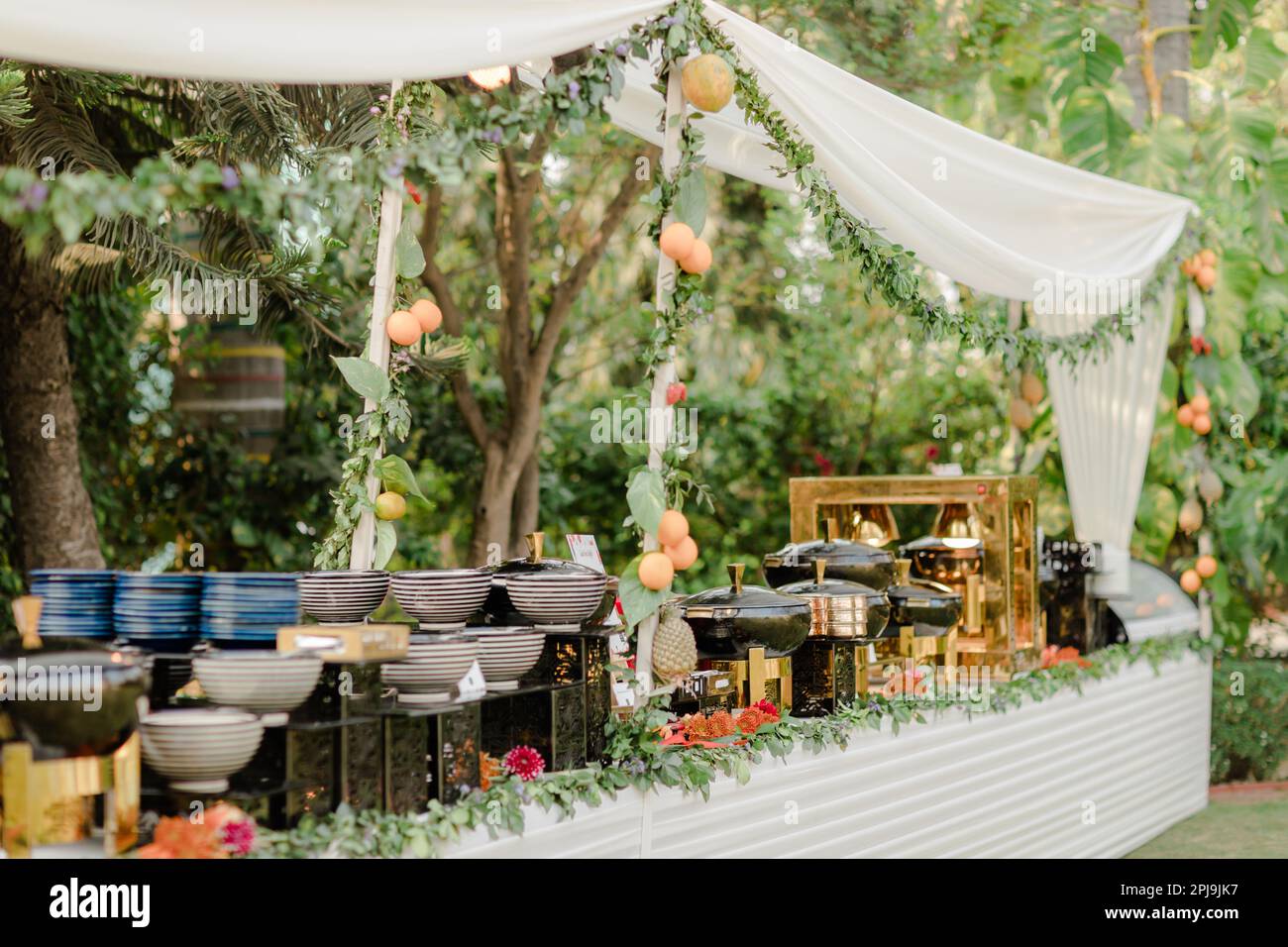 An outdoor buffet featuring a variety of vibrant colored dishes set up ...