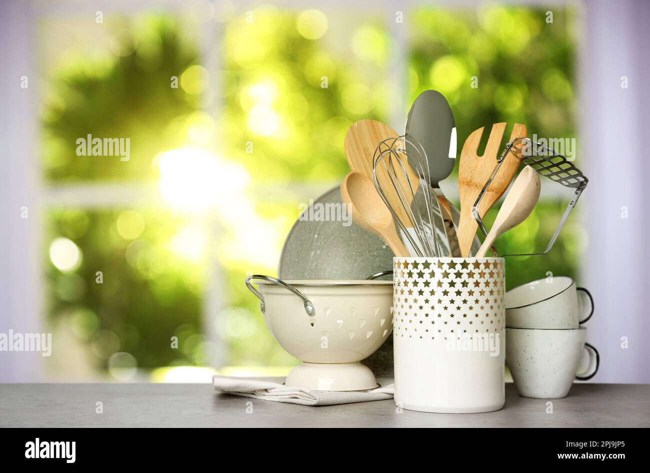 Different kitchen utensils on grey table indoors, space for text. Bokeh ...