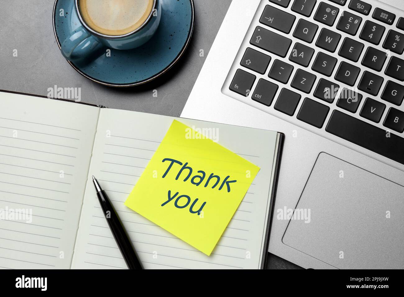 Sticky note with phrase Thank You, notebook, laptop, pen and cup of ...