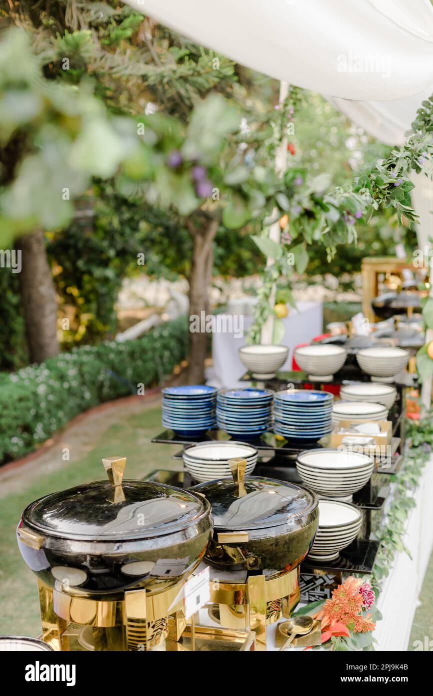 An outdoor buffet featuring a variety of vibrant colored dishes set up ...