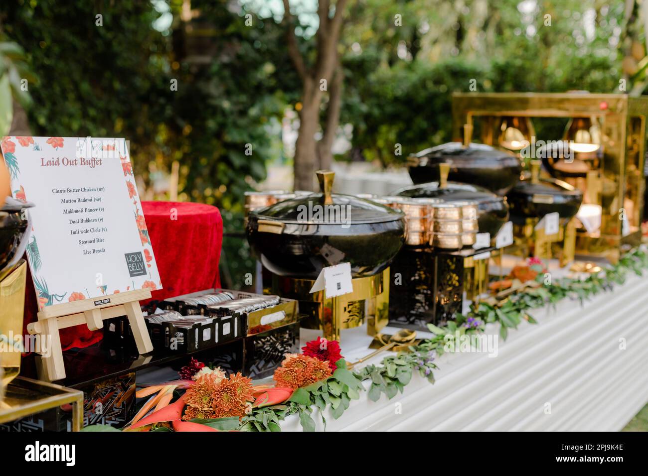 An outdoor buffet featuring a variety of vibrant colored dishes set up ...