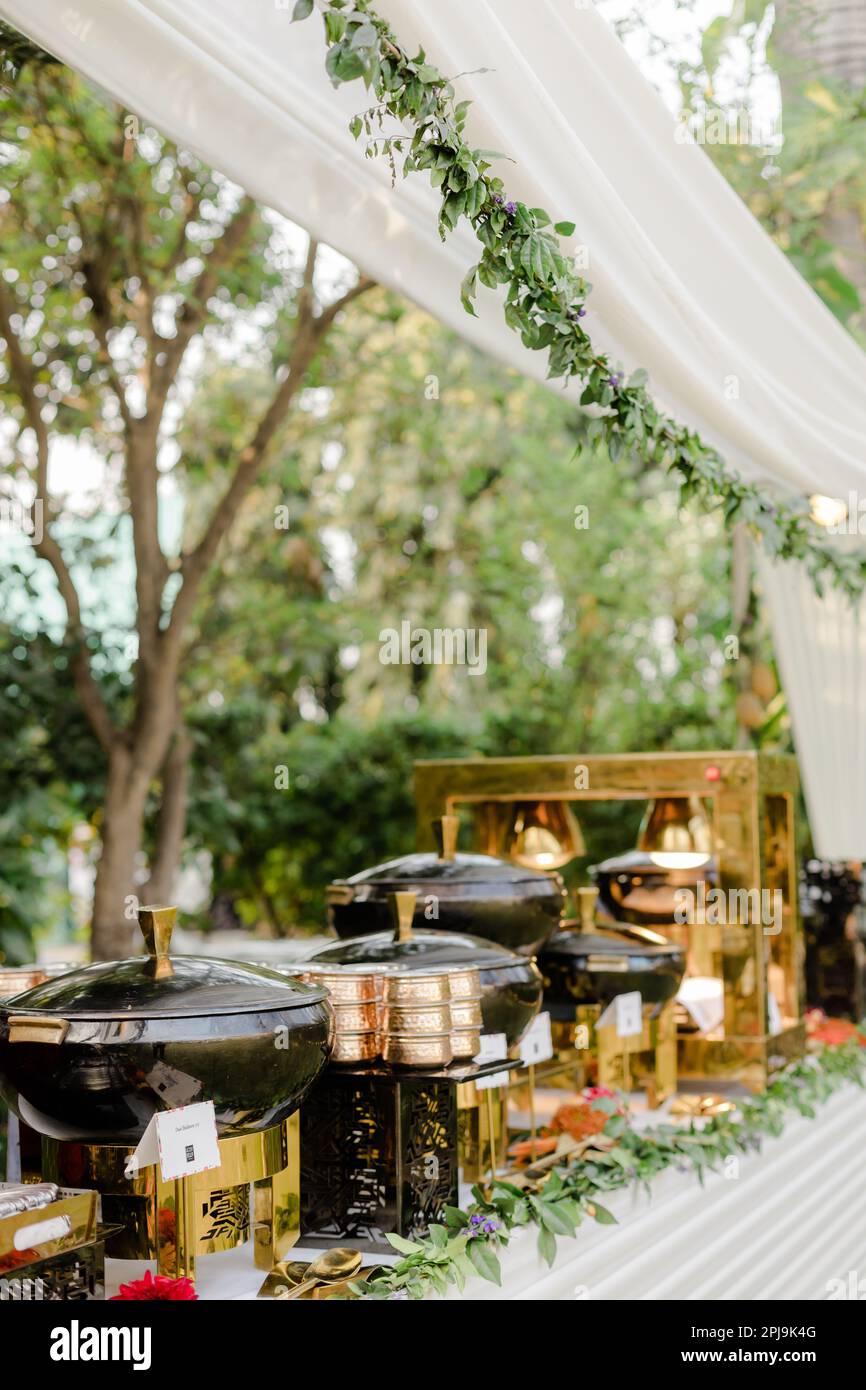 An outdoor buffet featuring a variety of vibrant colored dishes set up ...