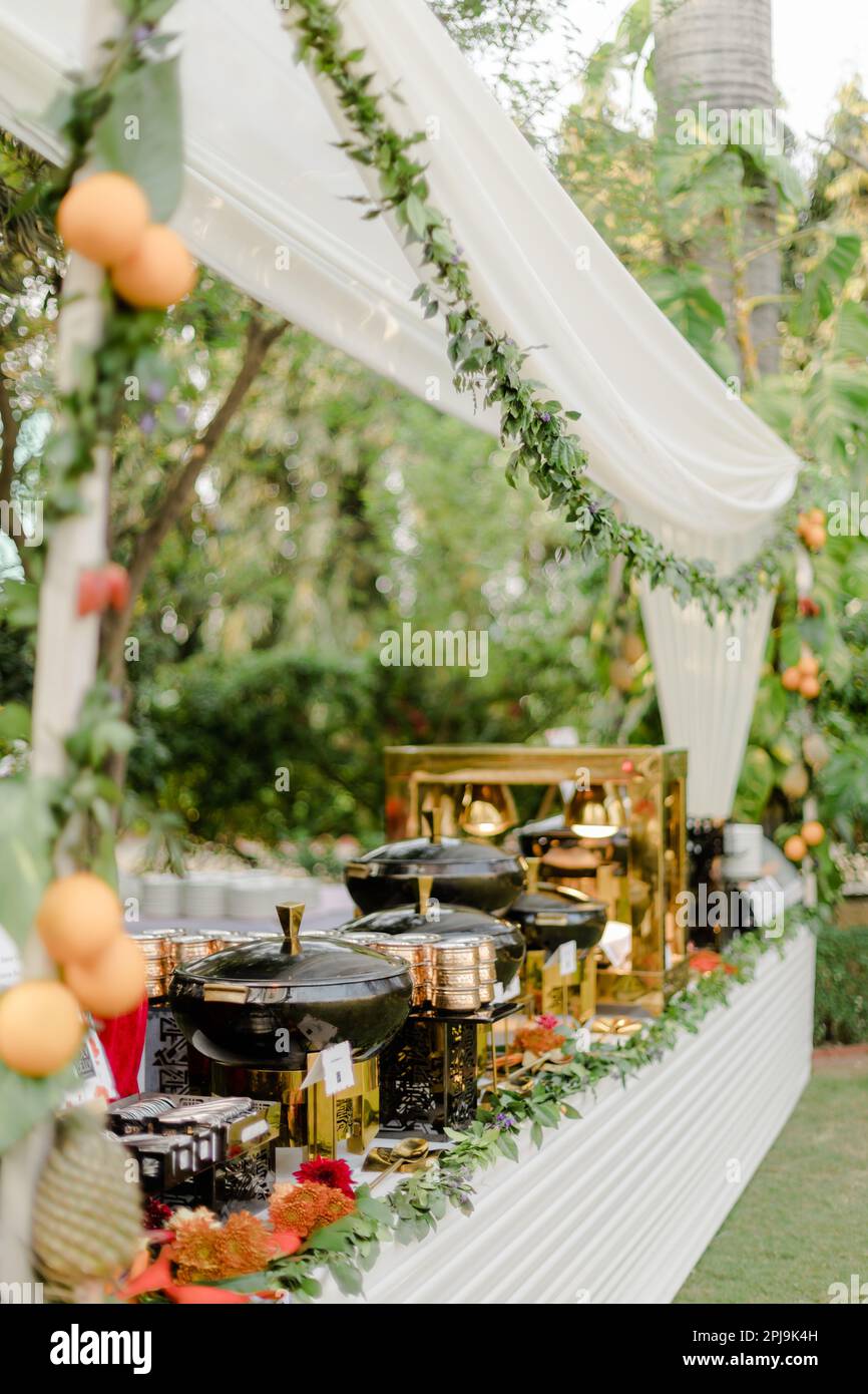 An outdoor buffet featuring a variety of vibrant colored dishes set up ...