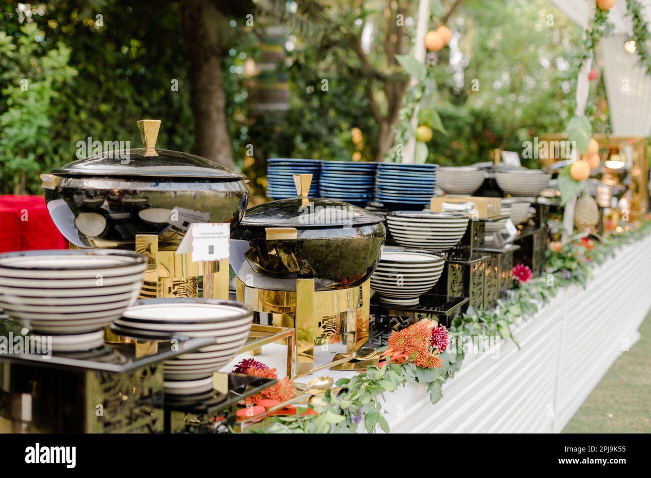 An outdoor buffet featuring a variety of vibrant colored dishes set up ...