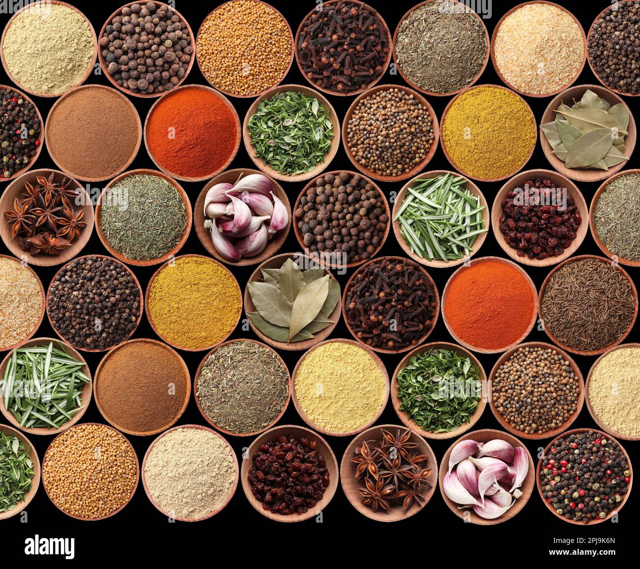 Collection of different aromatic spices and herbs on black background ...