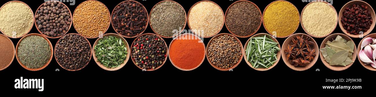 Collection of different aromatic spices and herbs on black background ...