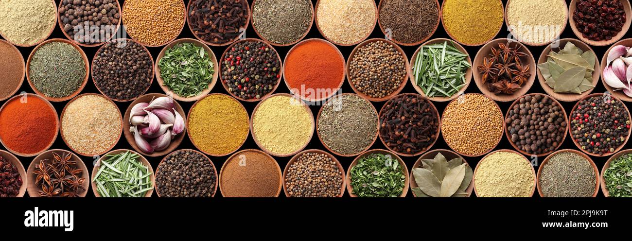 Collection of different aromatic spices and herbs on black background ...