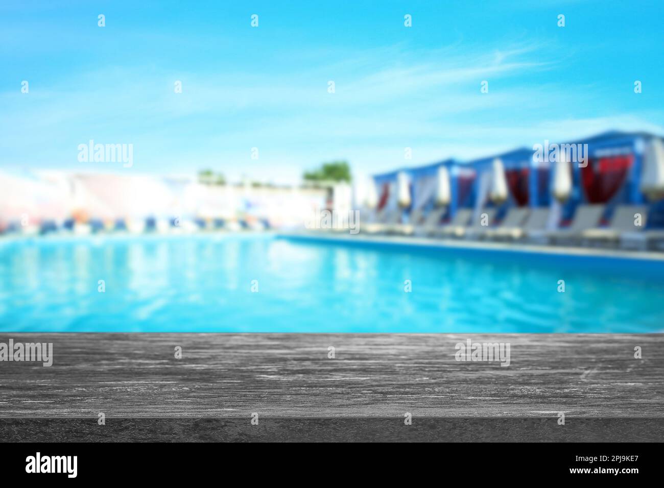 Empty stone surface near outdoors swimming pool with clear water. Space ...