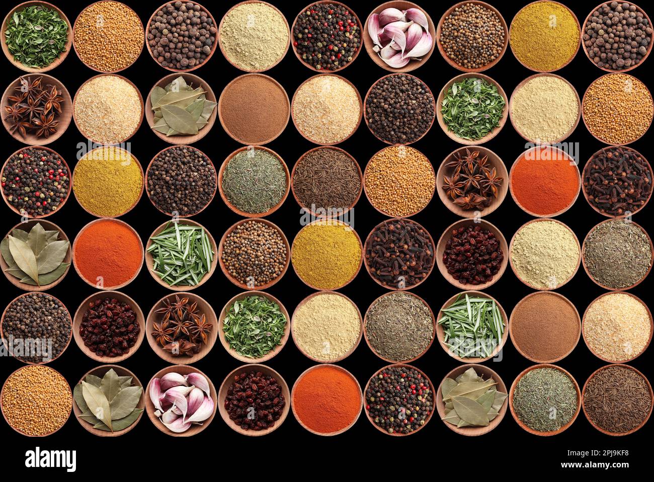 Collection of different aromatic spices and herbs on black background ...