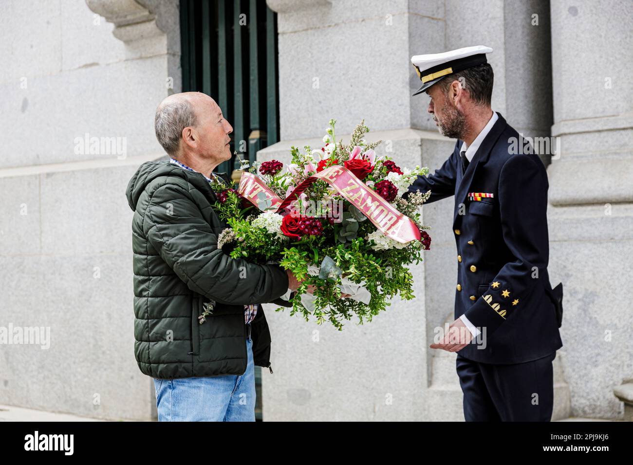 A man hands a military man a wreath for the mortuary chapel of the ...