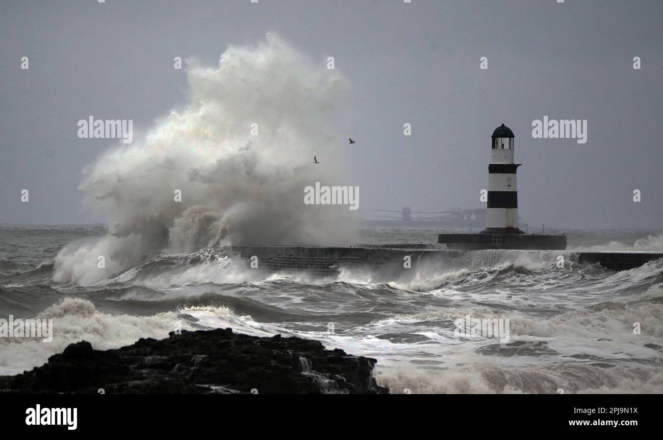 Waves crash against the lighthouse in Seaham Harbour, County Durham ...