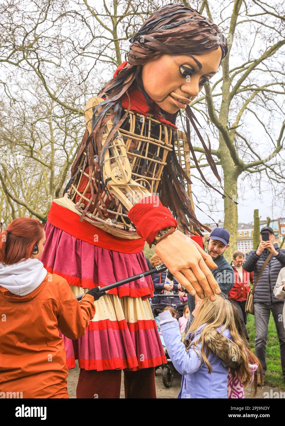 London, UK. 01st Apr, 2023. Little Amal interacts and greets walkers ...