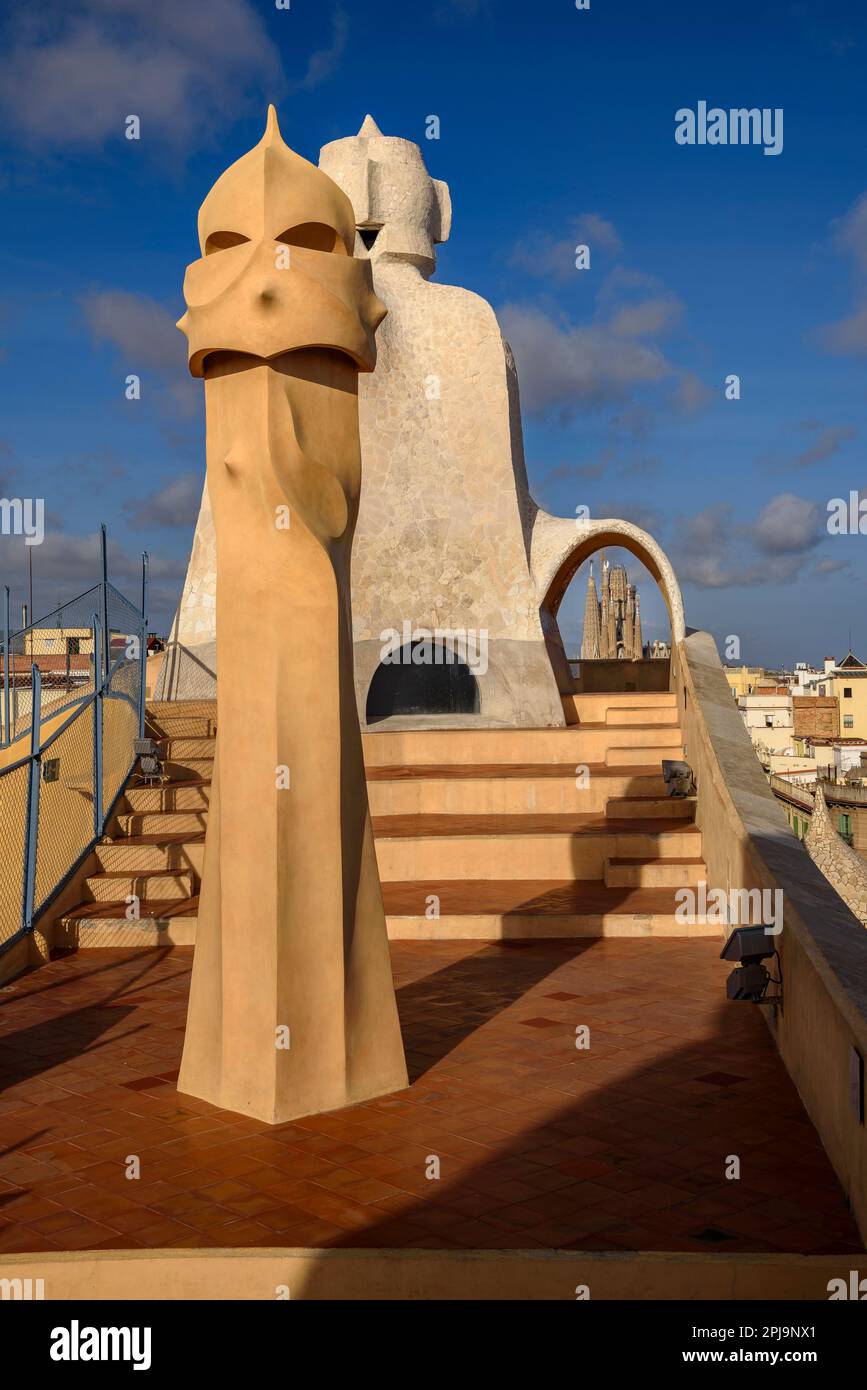 Rooftop chimneys of Casa Milà - La Pedrera with the Sagrada Familia in ...