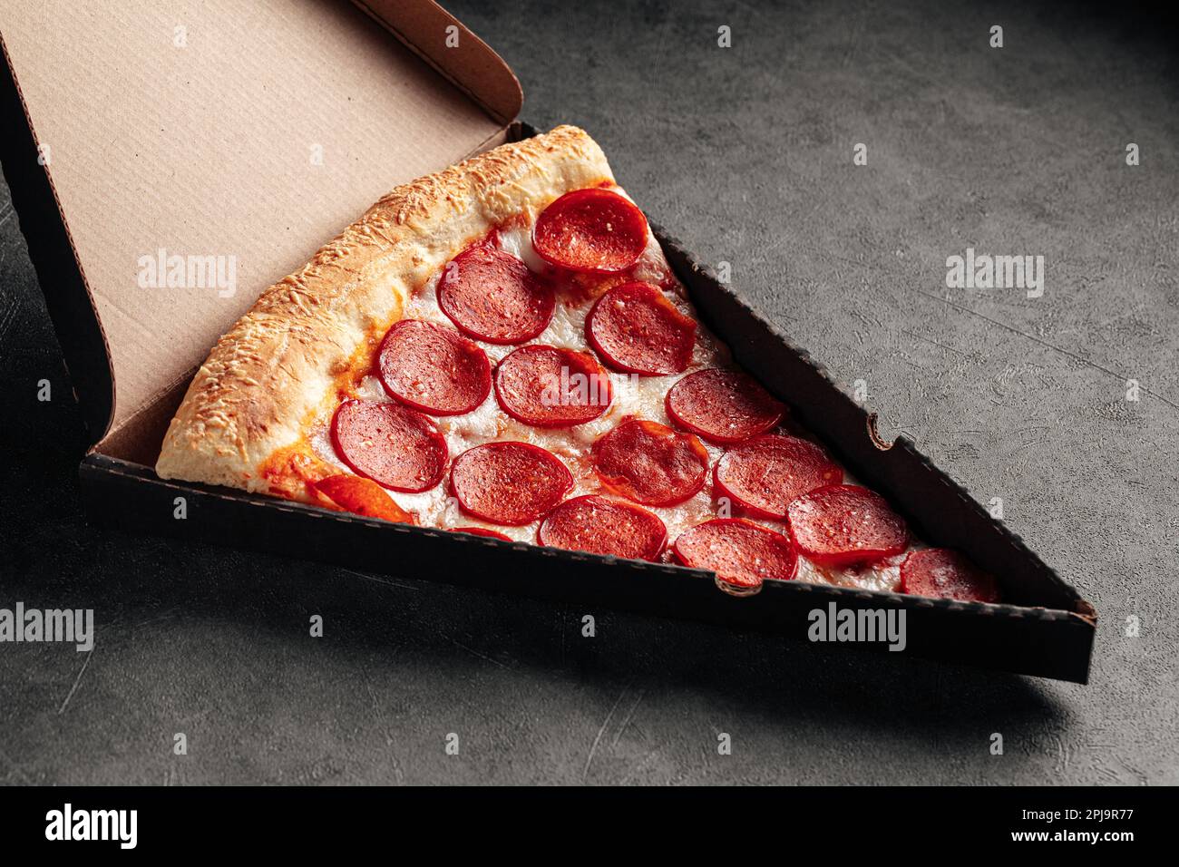 Take away box with slice of giant pepperoni pizza Stock Photo - Alamy