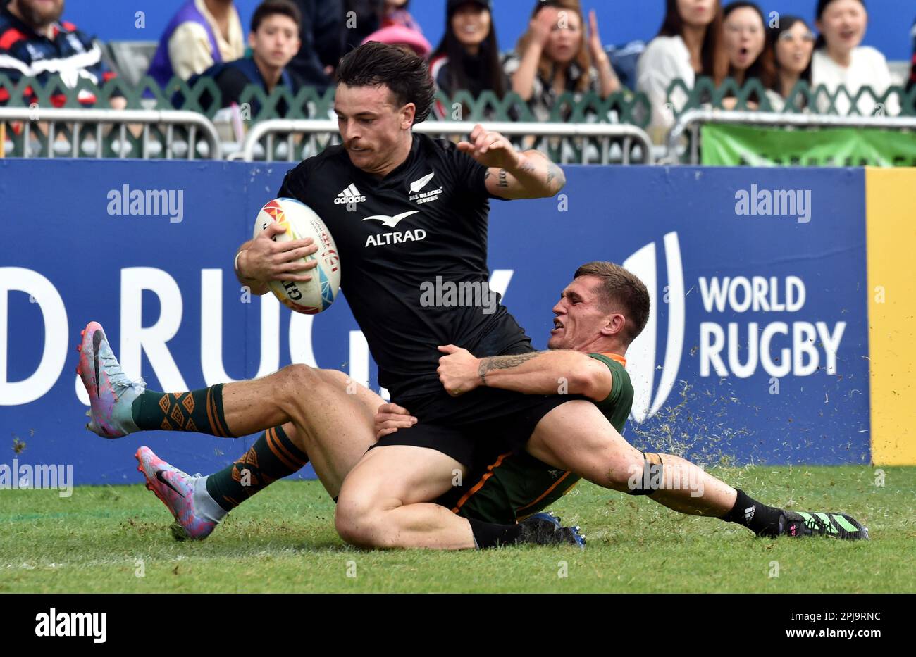 Hong Kong. 1st Apr, 2023. Leroy Carter (top) of New Zealand vies with ...