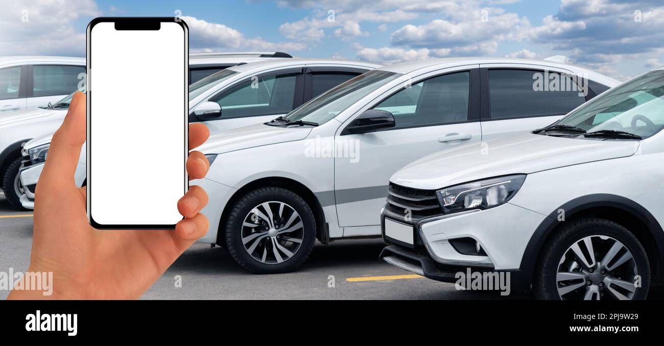 Hand with phone on a background of rows of cars. Car sales. High ...