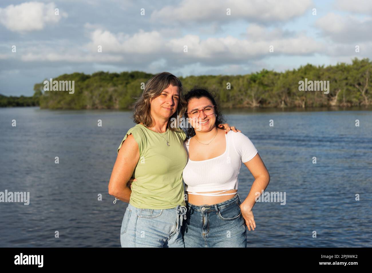 Mother and daughter together on the pier near the river in the late ...
