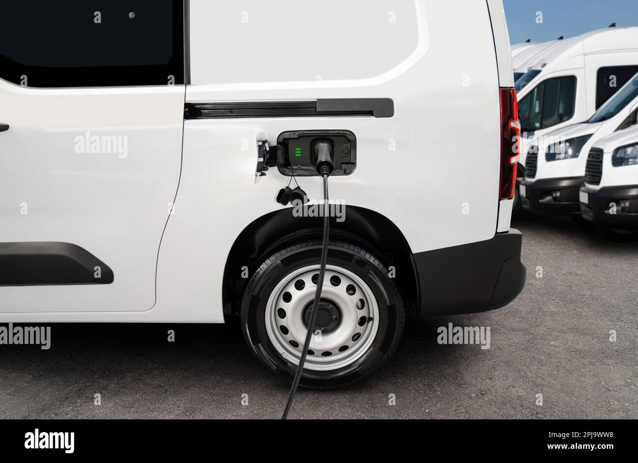 Electric delivery van with connected charging cable. High quality photo ...