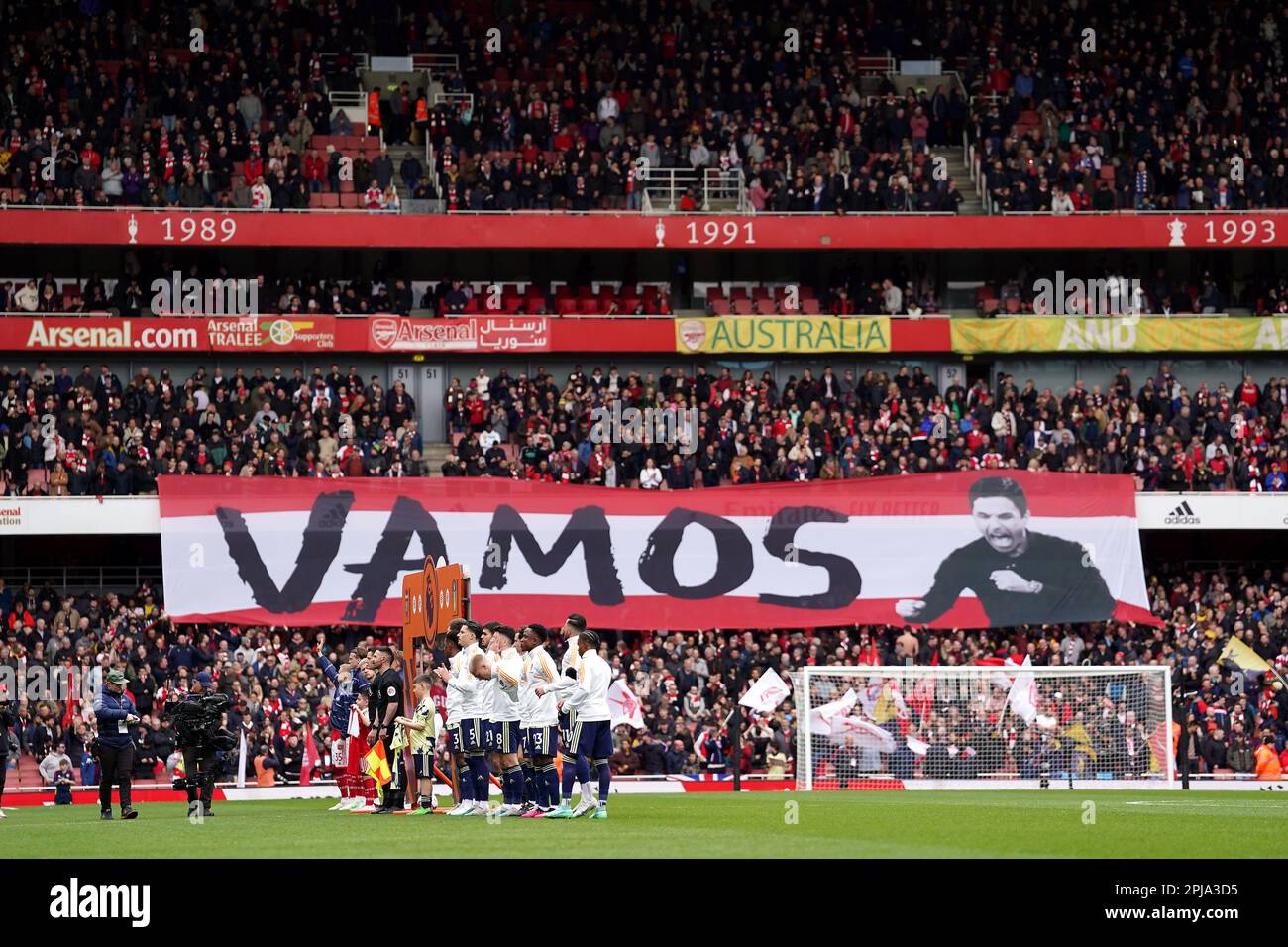 Arsenal and Leeds United players line up as fans hold up a banner for ...