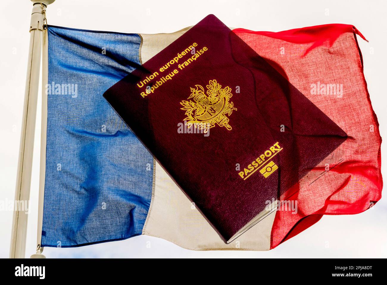 A French passport rests against the backdrop of the blue, white, and ...