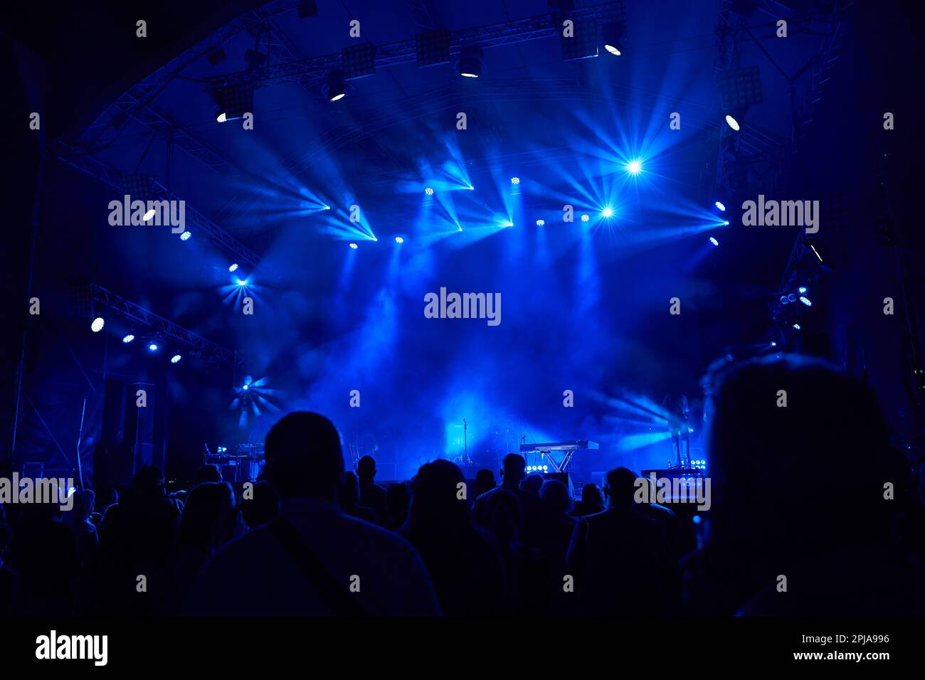 Colourful concert arena with a crowd silhouette against stage lights ...