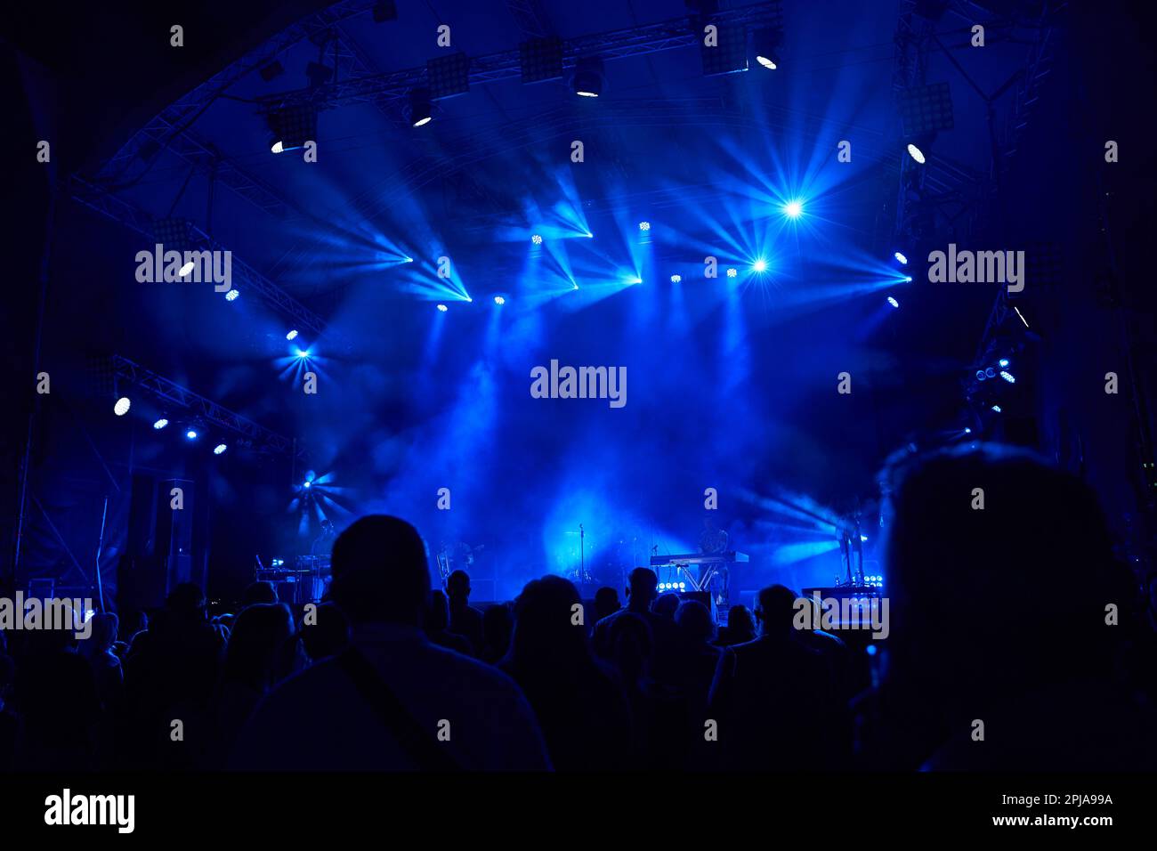 Colourful concert arena with a crowd silhouette against stage lights ...