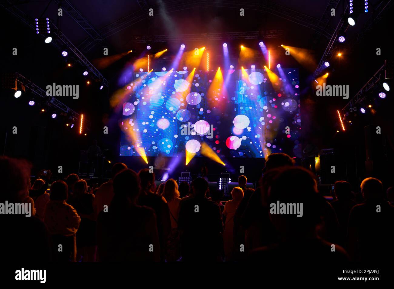 Colourful concert arena with a crowd silhouette against stage lights ...