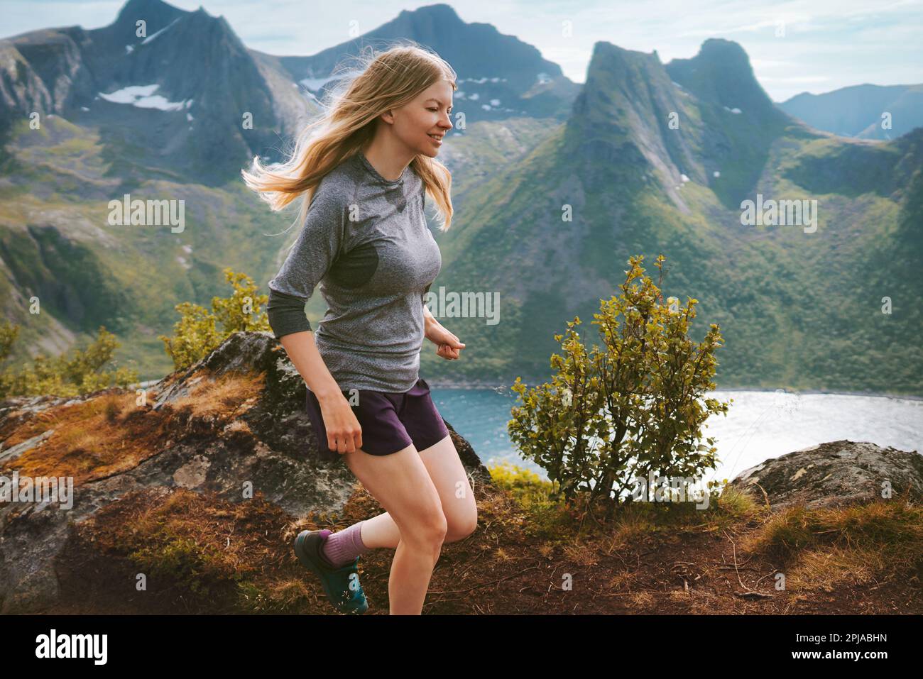 Active woman running in mountains of Norway outdoor travel adventure ...