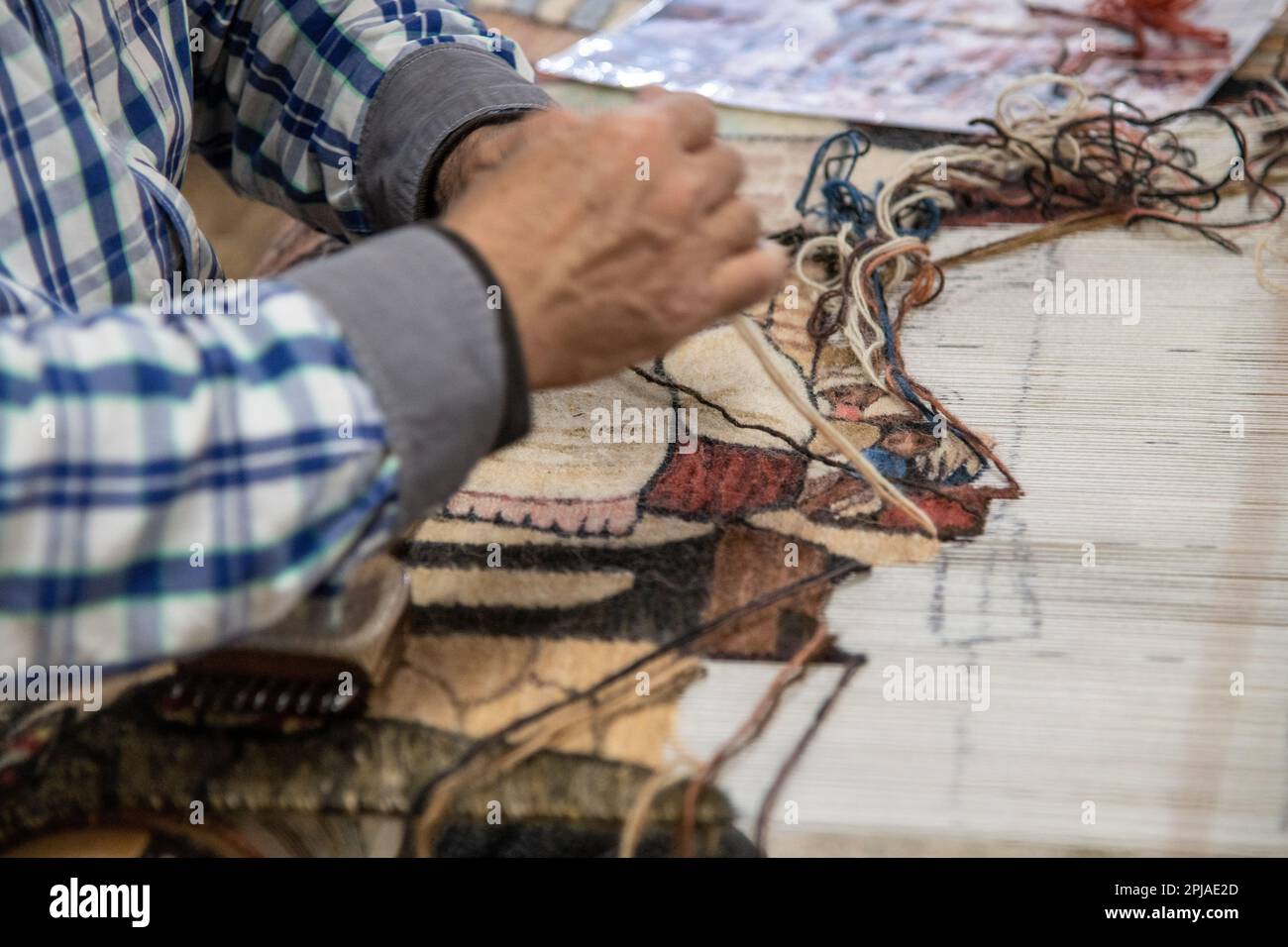 A man weaving a rug at an Egyptian carpet factory Stock Photo - Alamy