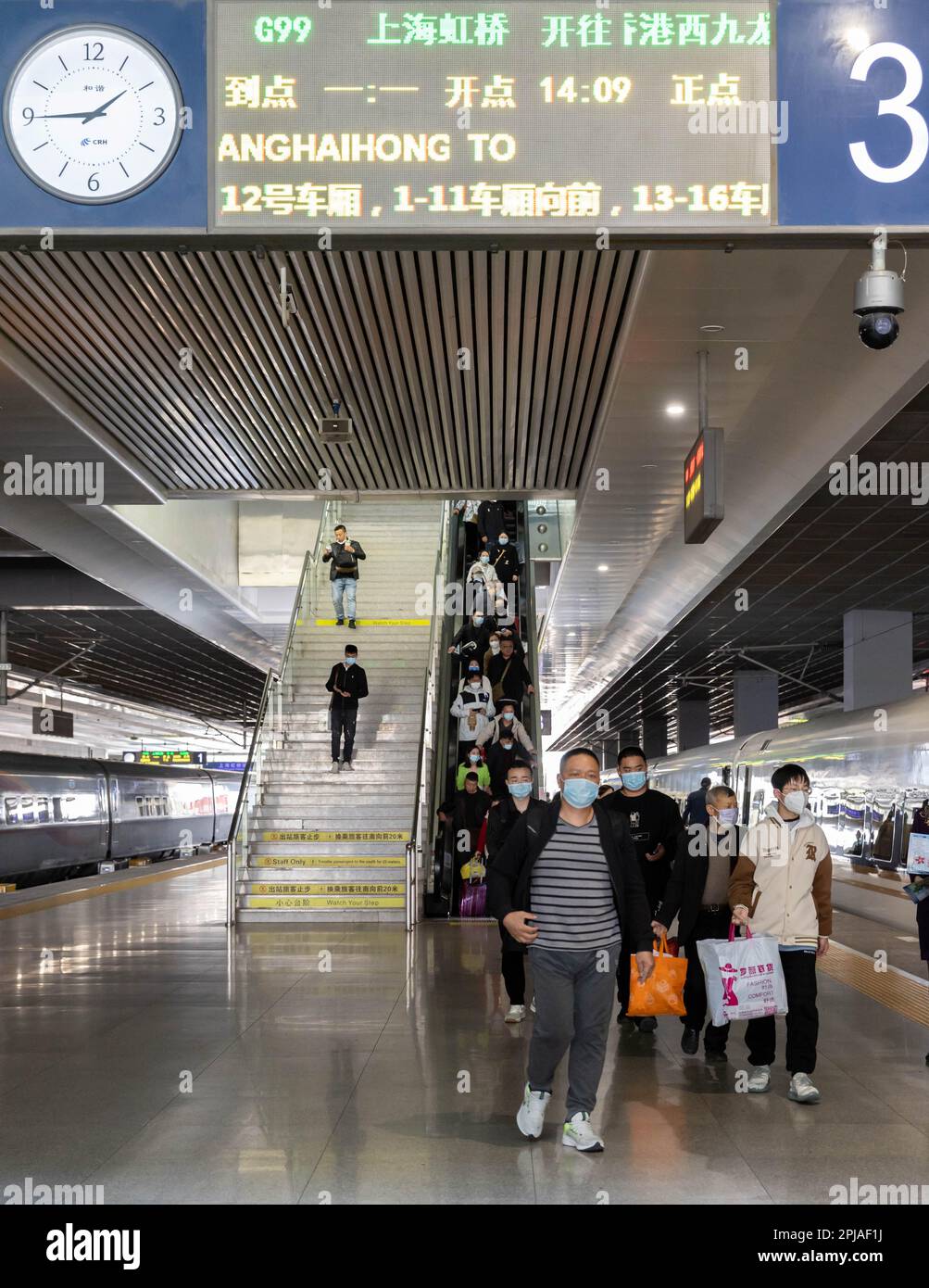 Shanghai. 1st Apr, 2023. Passengers walk to board the train G99 at ...