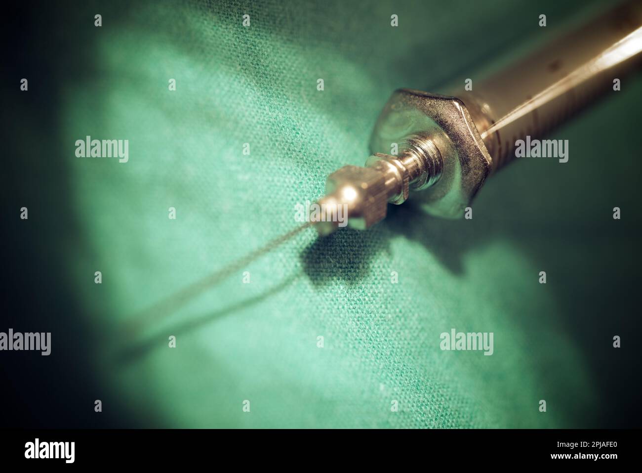 Retro syringe on a green hospital fabric Stock Photo - Alamy