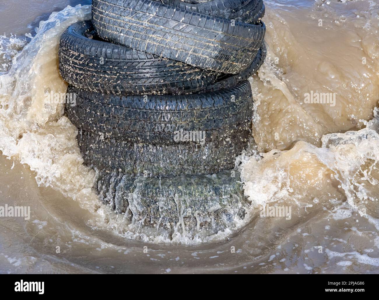 Water waves crash into a coastal barrier made of old tires Stock Photo ...
