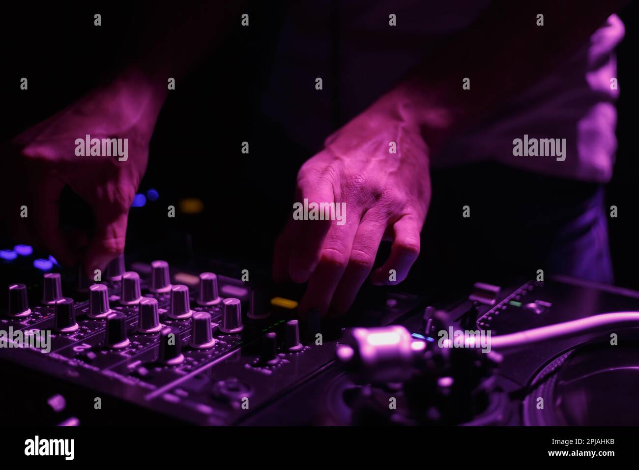 Hip hop DJ mixing music in dark night club. Hands of disc jockey ...