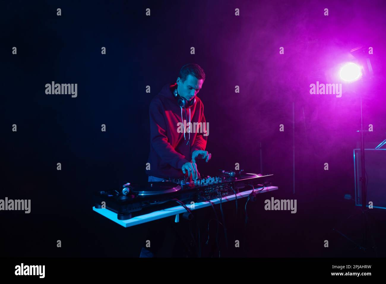 Professional DJ mixing vinyl records on a hip hop party. White male ...