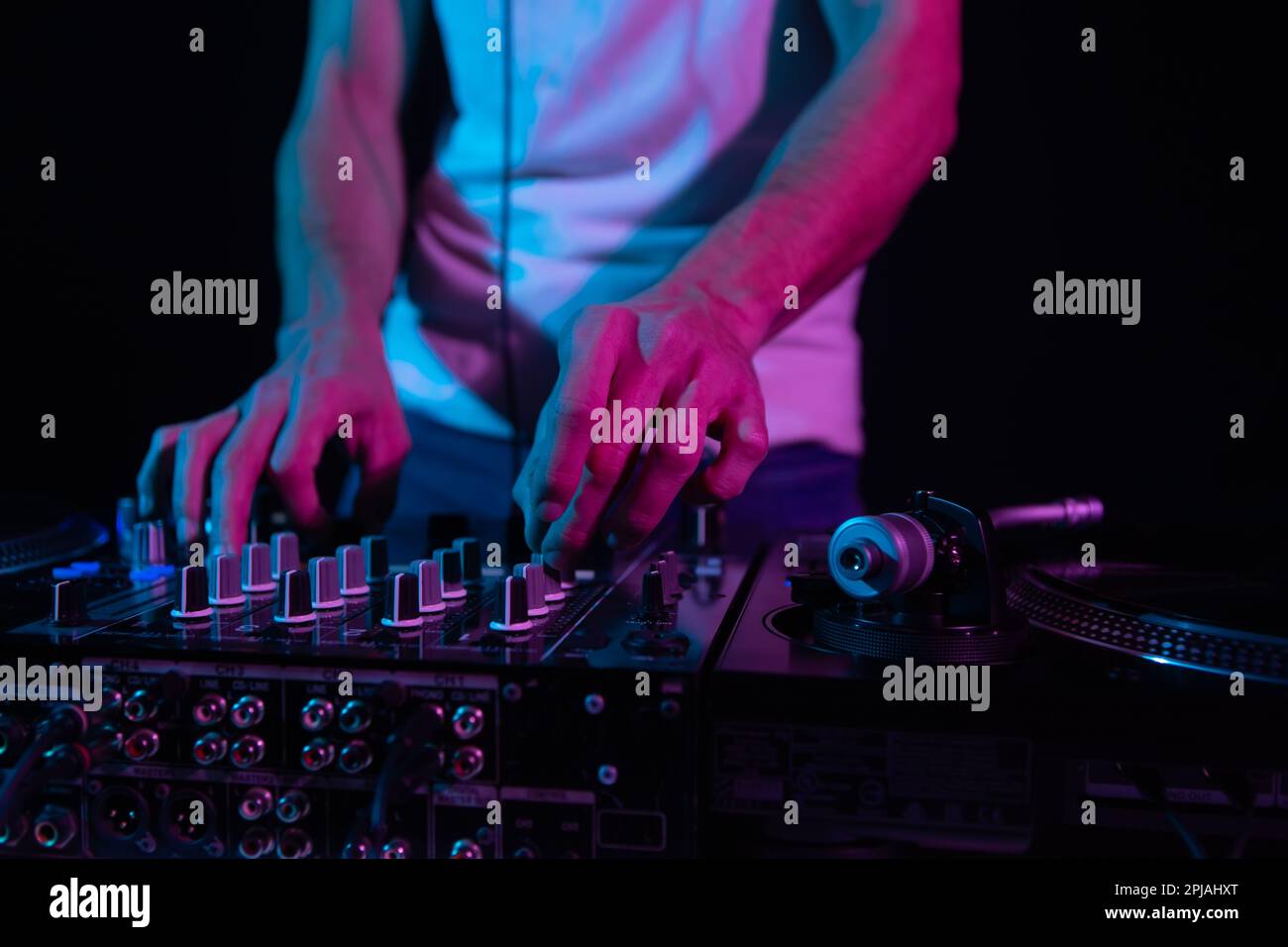 Hands of club DJ mixing music. Professional disc jockey plays set with ...