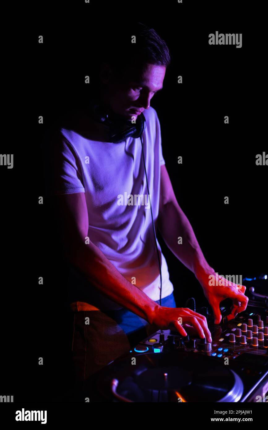 Cool young DJ playing music on party in night club. Night club disc ...