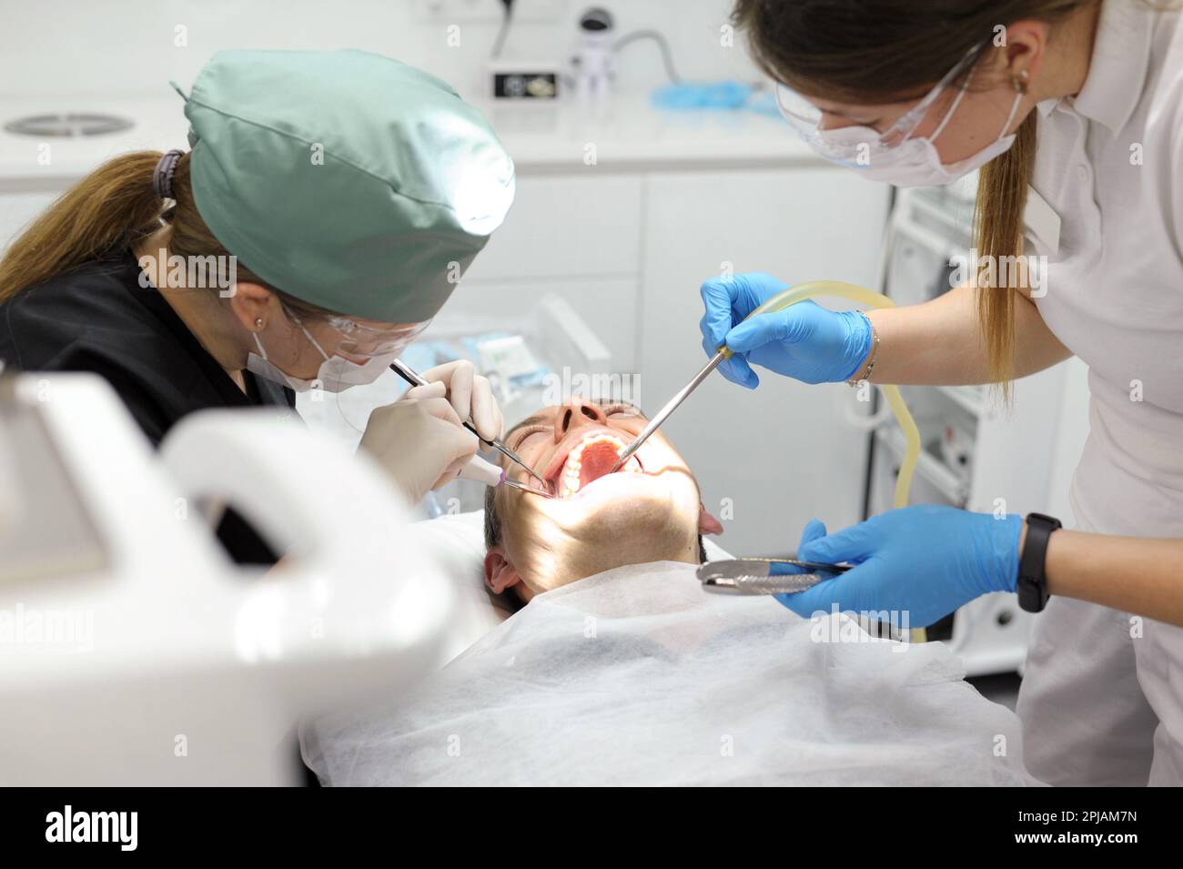 hands of doctor hold key nozzle and piezoelectric scaler removal of ...