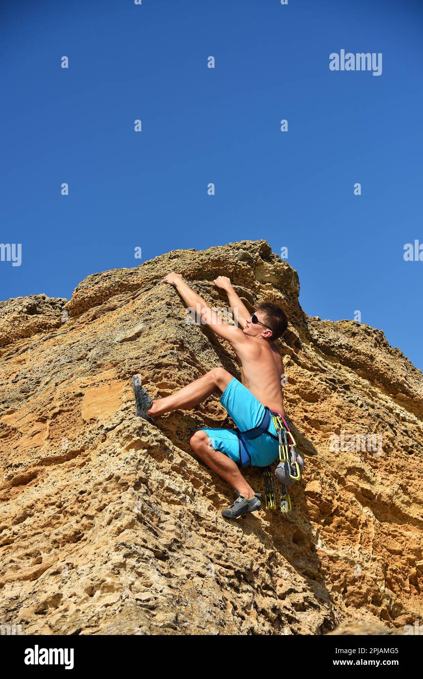 athletic male rock climber climbing on cliff wall Stock Photo - Alamy