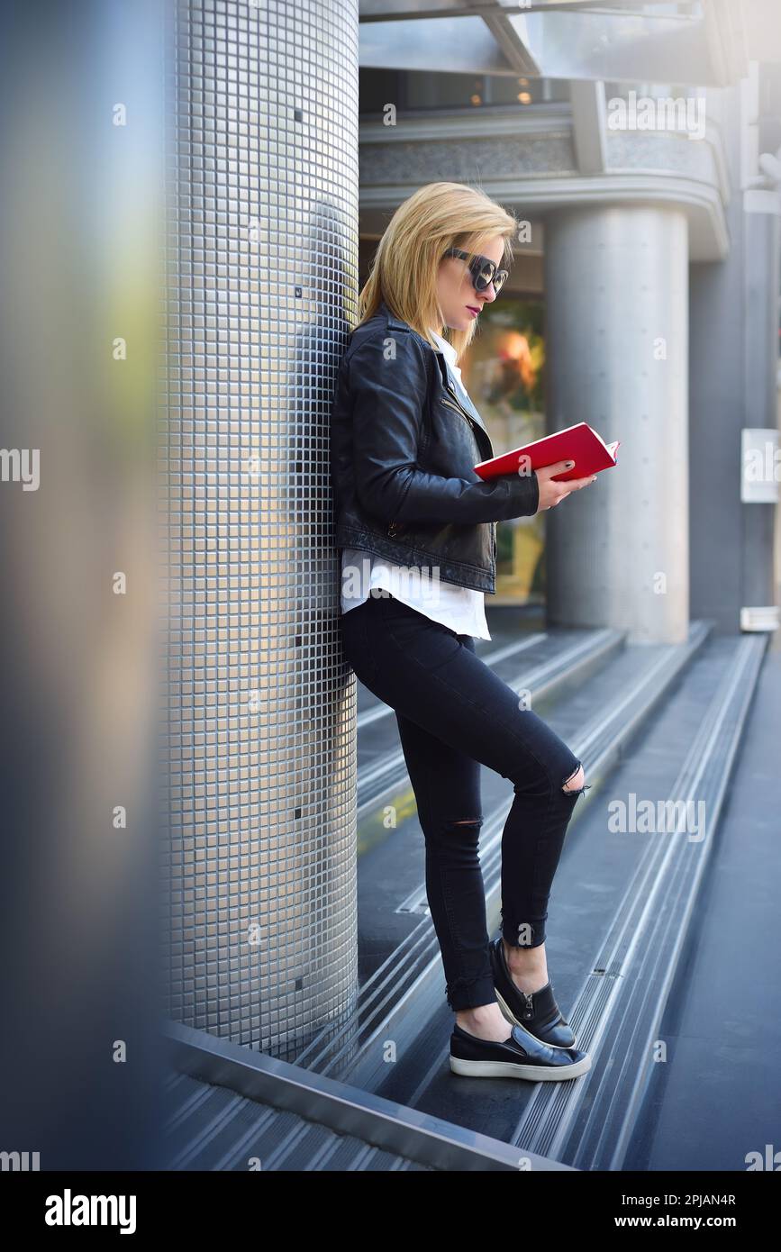 young hipster girl reading a red book Stock Photo - Alamy