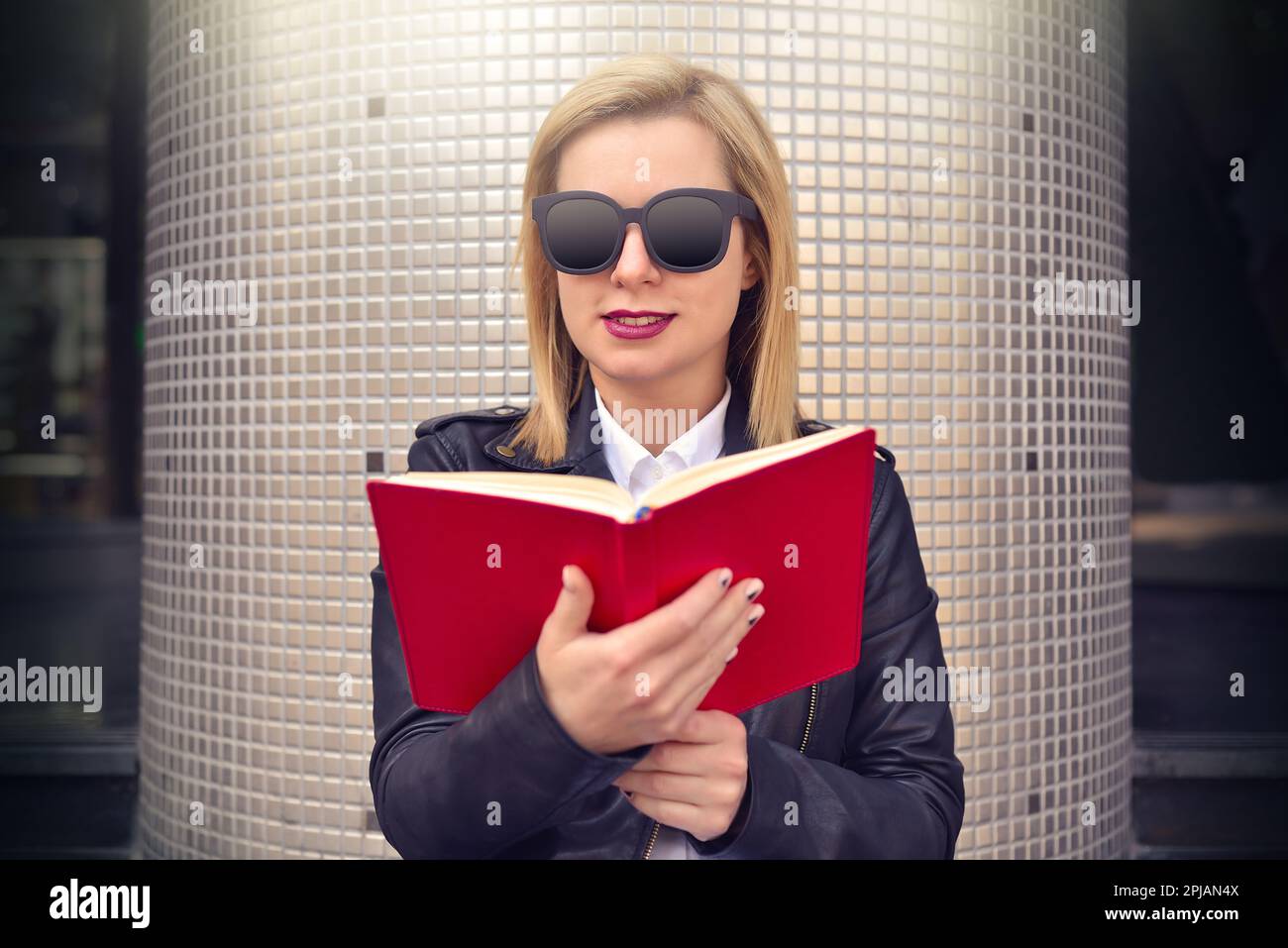 young hipster girl reading a red book Stock Photo - Alamy