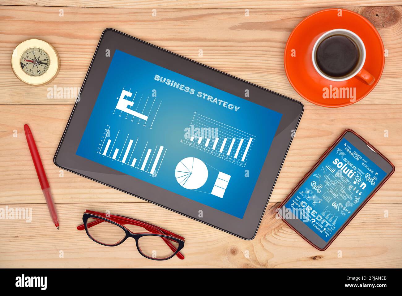 Touch pad with business strategy on screen and many objects on wooden ...